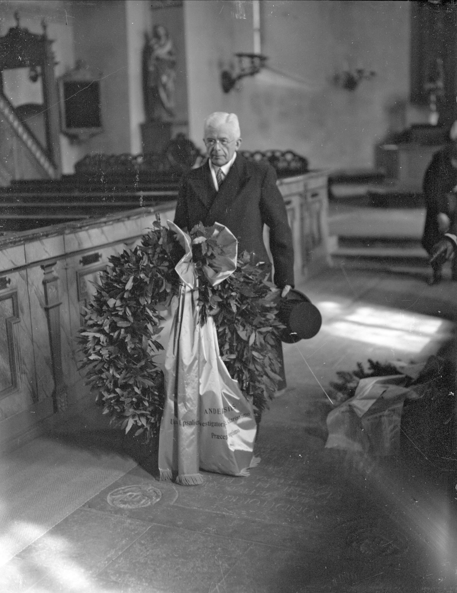 Man med krans vid Anders Celsius grav i Gamla Uppsala kyrka tvid 200 ...