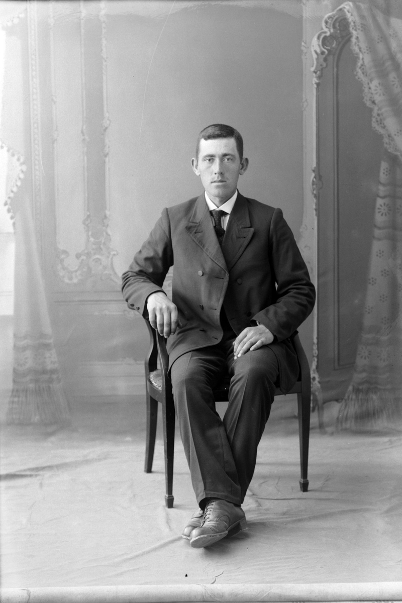 Studioportrett i helfigur av en sittende mann. - Sør-Troms Museum ...