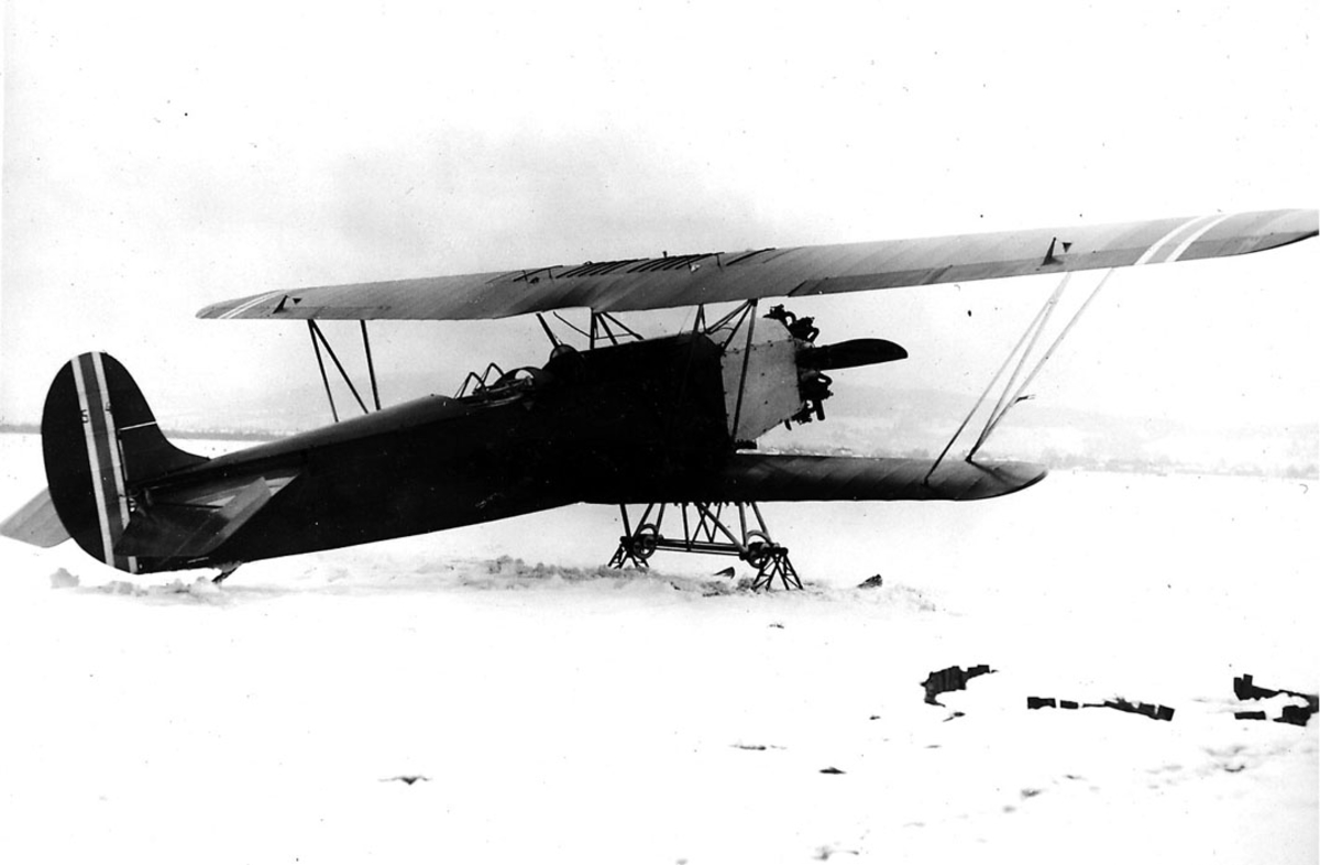 Åpen plass, ett fly på bakken, Fokker CVE med skiunderstell. Snø på ...