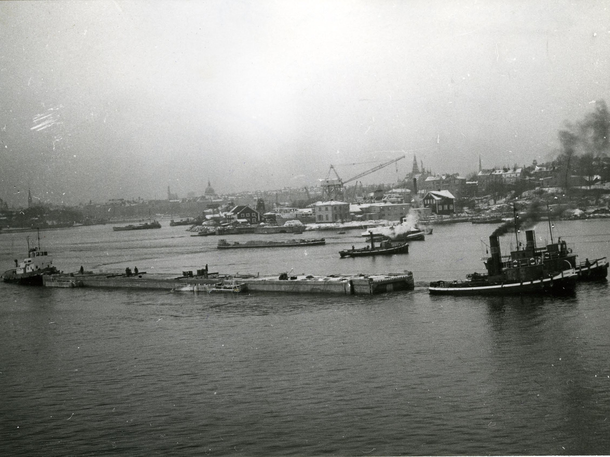 Bogsering av tunnelbanedelar vid Slussen. - Sjöhistoriska museet ...
