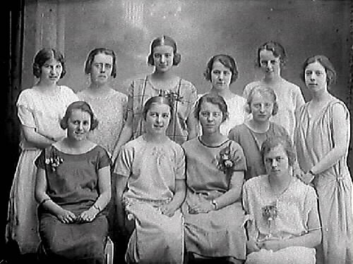 Ateljébild. Avgångsklass från flickskolan. Lärarinnan Harriet Ljungström. Stående från höger ...