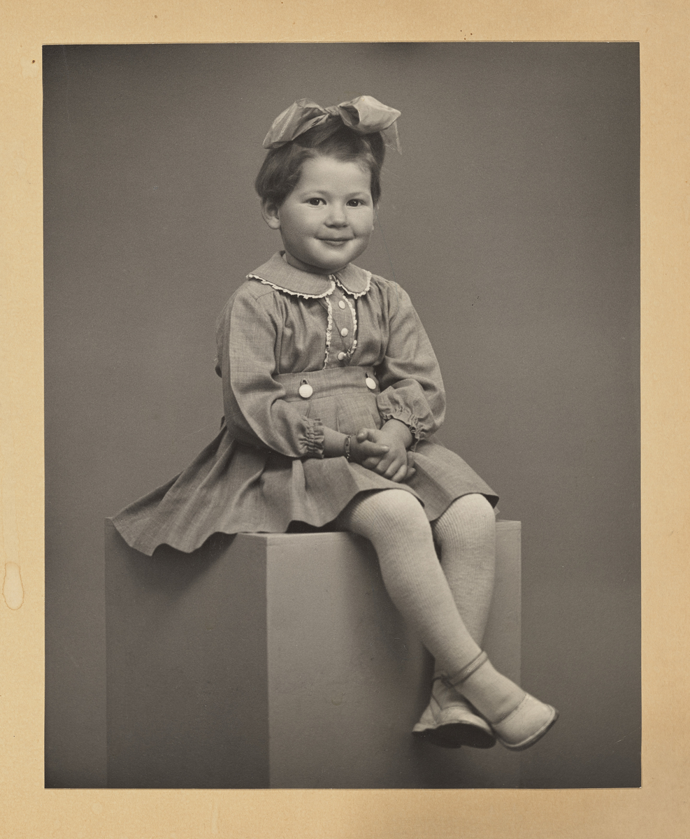 Jente sittende på en boks. - Museene i Akershus / DigitaltMuseum