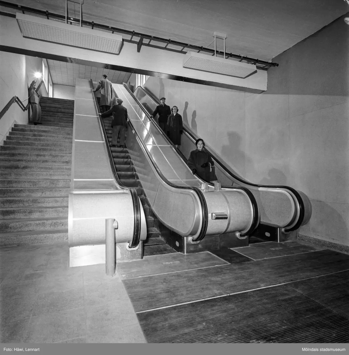 Kvinnor och män åker i pappersbruket Papyrus rulltrappa. Mölndal, 7/12 ...