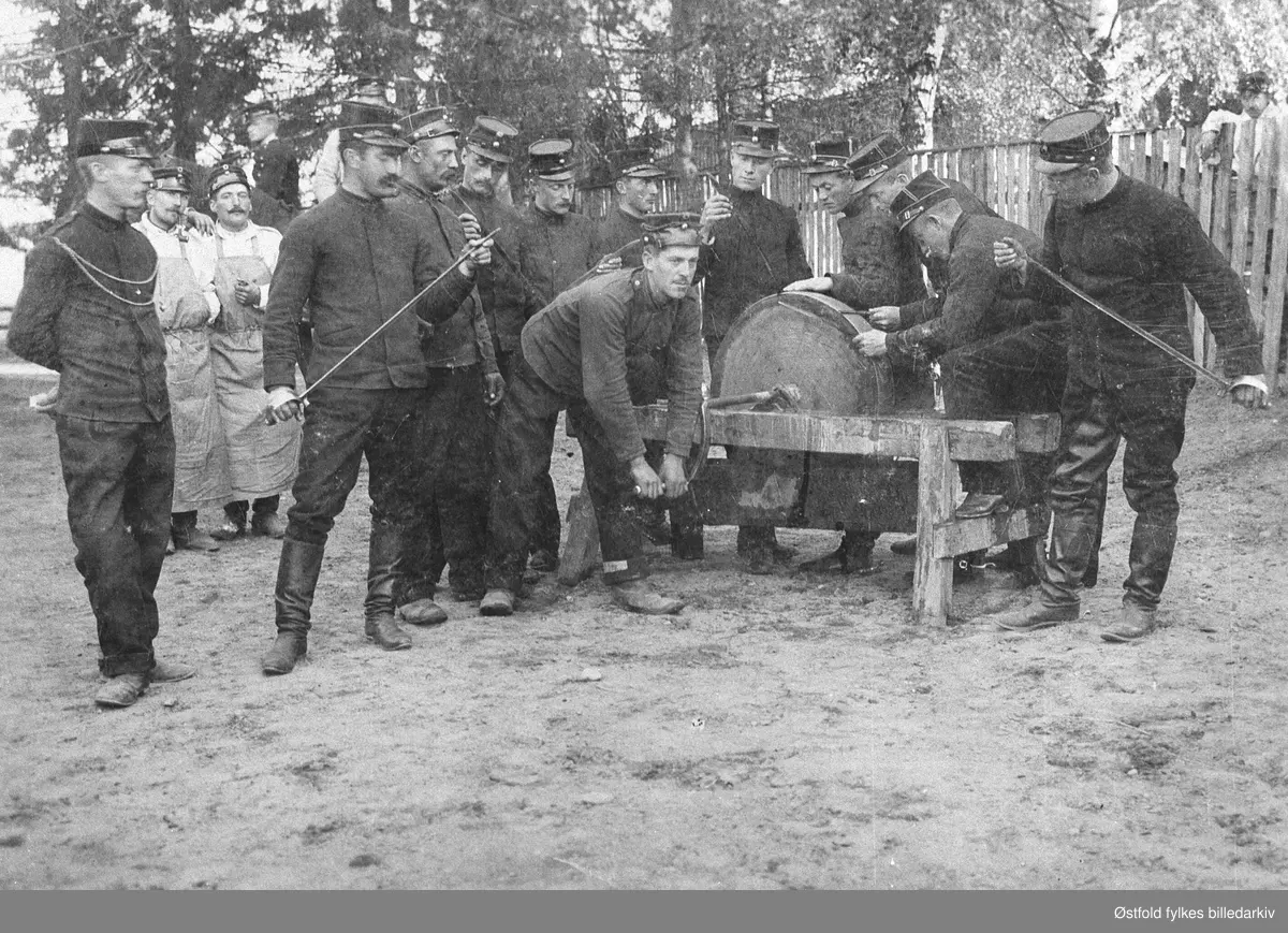 Soldater i uniform sliper sabler på hånddrevet slipestein, Gardermoen ...