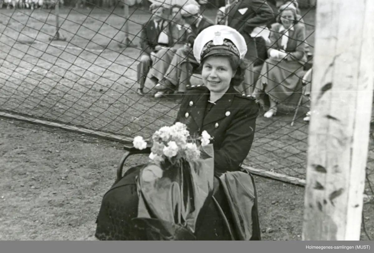 Utendørs foto av kvinne i politiuniform sittende med blomsterbukett i ...