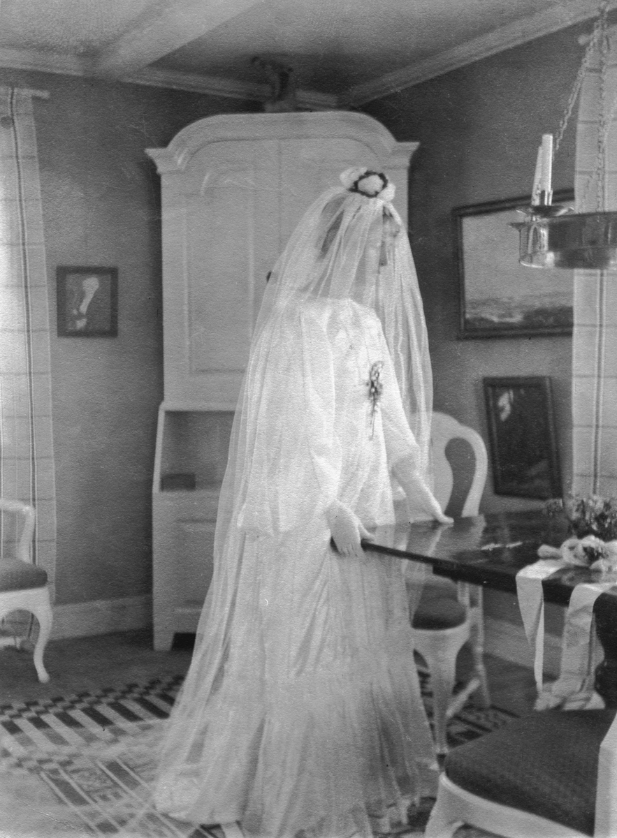 Ester Ellqvist-Bauer står klädd i sin brudklänning och slöja i stugan i ...