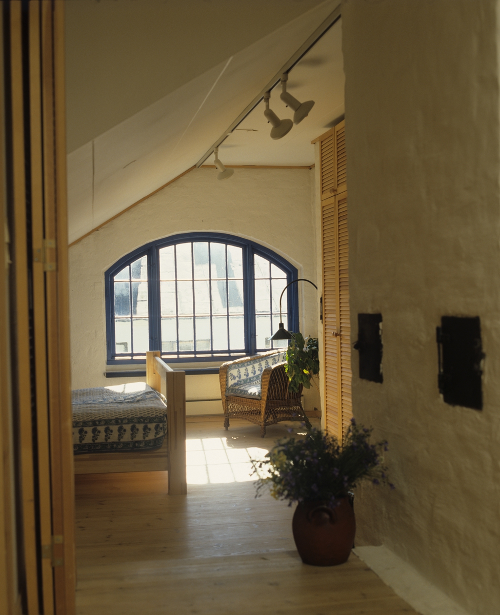 Soverom med buet vindu i utbygd loft i en gammel bygård ...