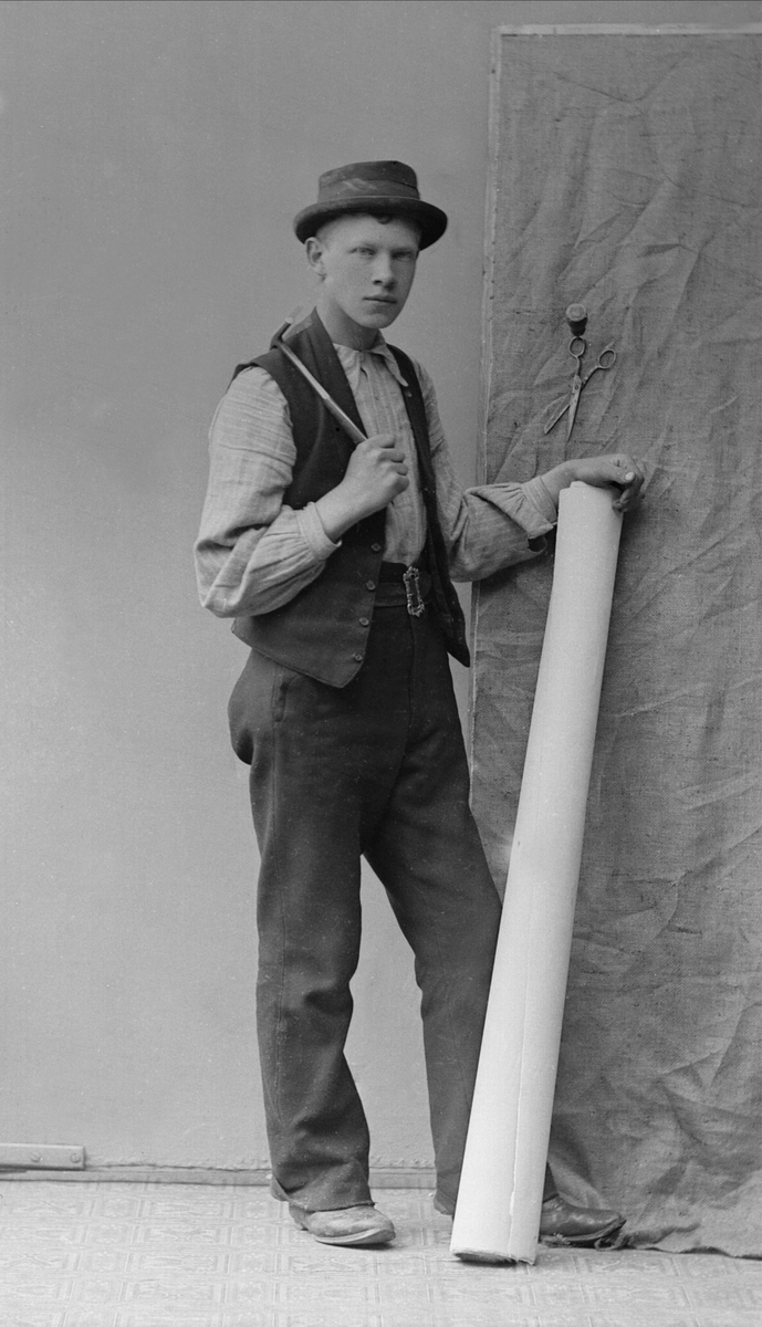 Portrett, mann i arbeidsklær med verktøy og materialer. Liten hammer i ...